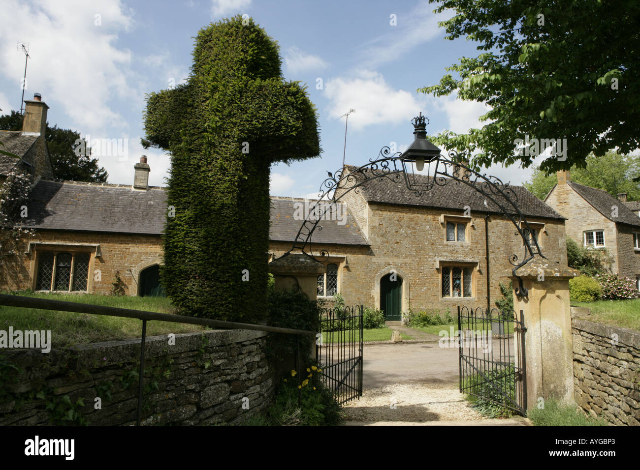 A yew tree cut into the shape of a cross outside the Church gate way at ...
