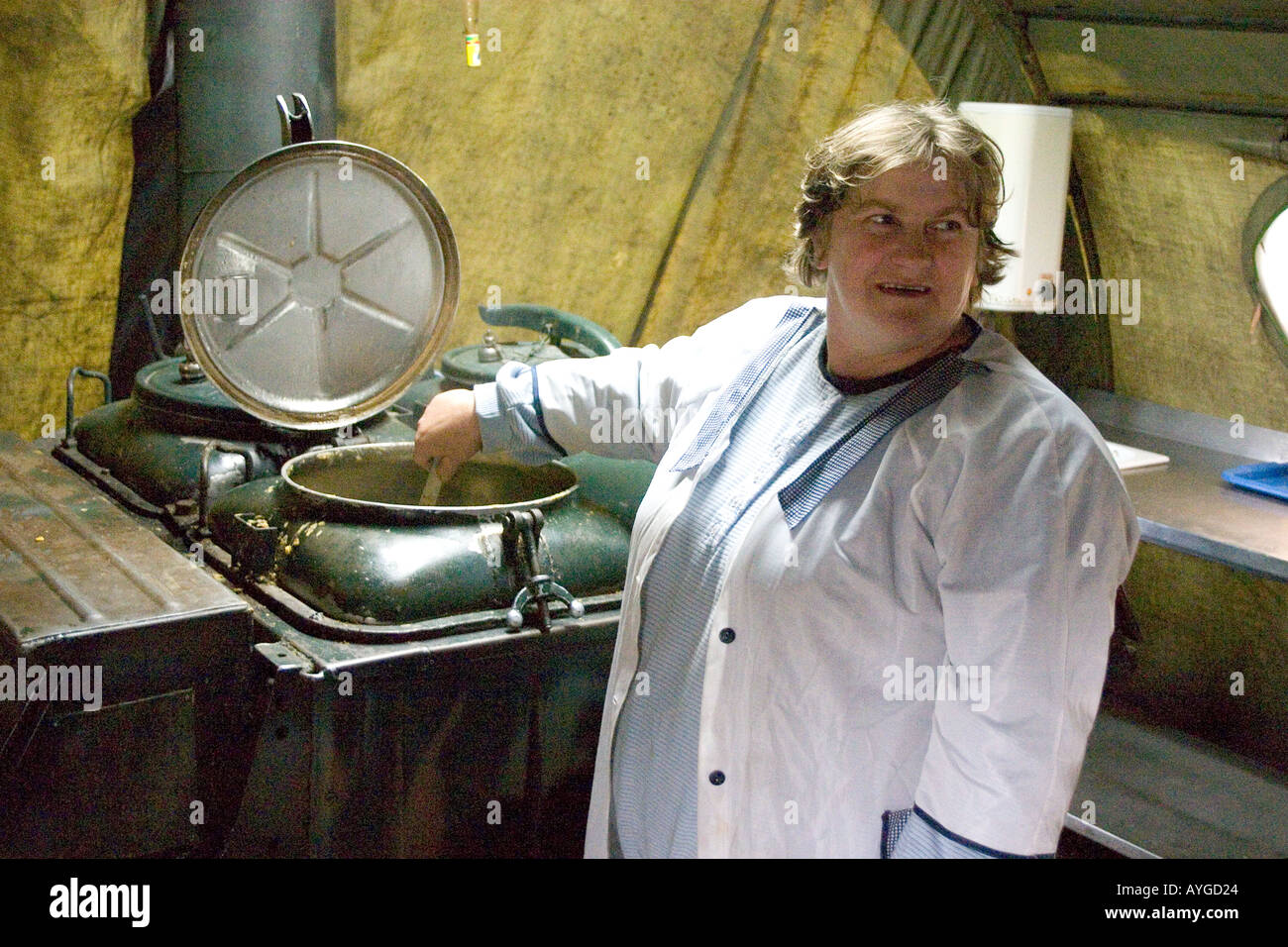 Cook stirring soup at the site of a mock military mess hall where soup ...