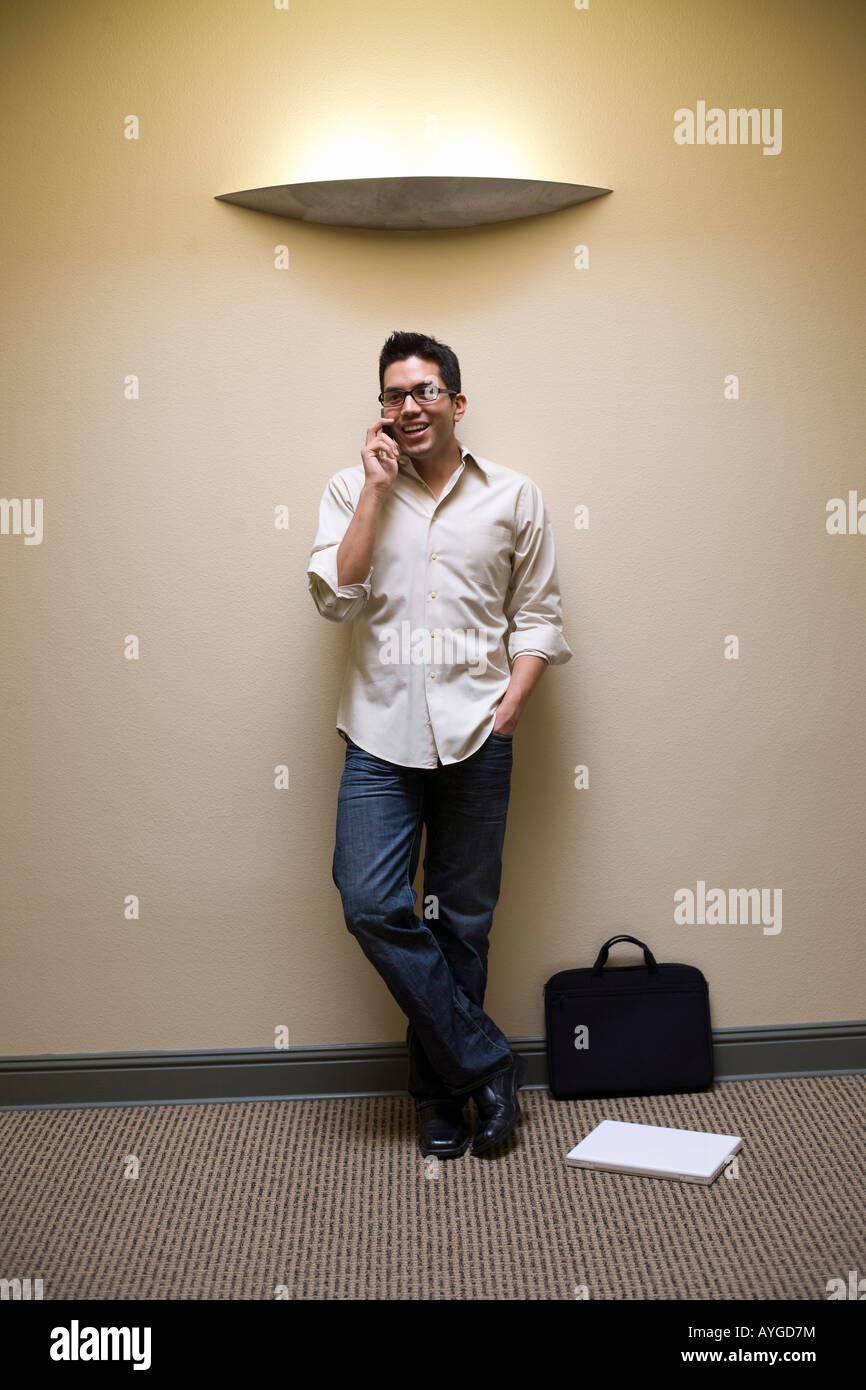 Employee talking on cell phone in office hallway Stock Photo - Alamy