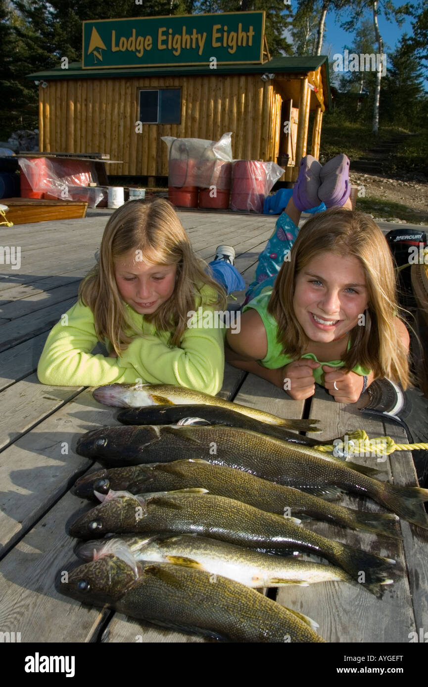 two young ladies with their catch on a dock Stock Photo - Alamy