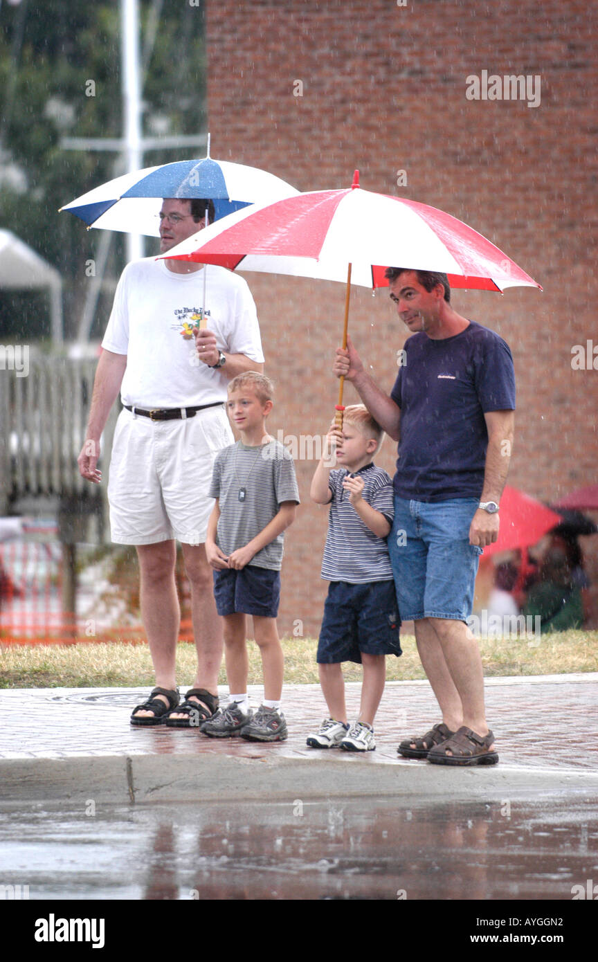 Pedestrian with umbrella protection is caught in rain storm on a public ...