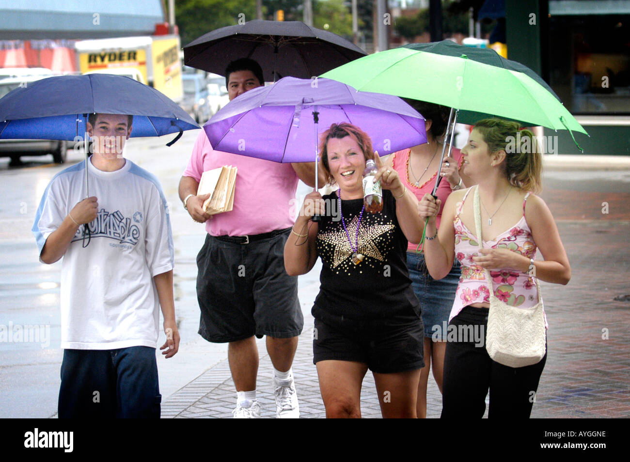 Pedestrian with umbrella protection is caught in rain storm on a public ...