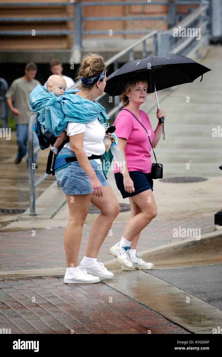 Pedestrian with umbrella protection is caught in rain storm on a public ...