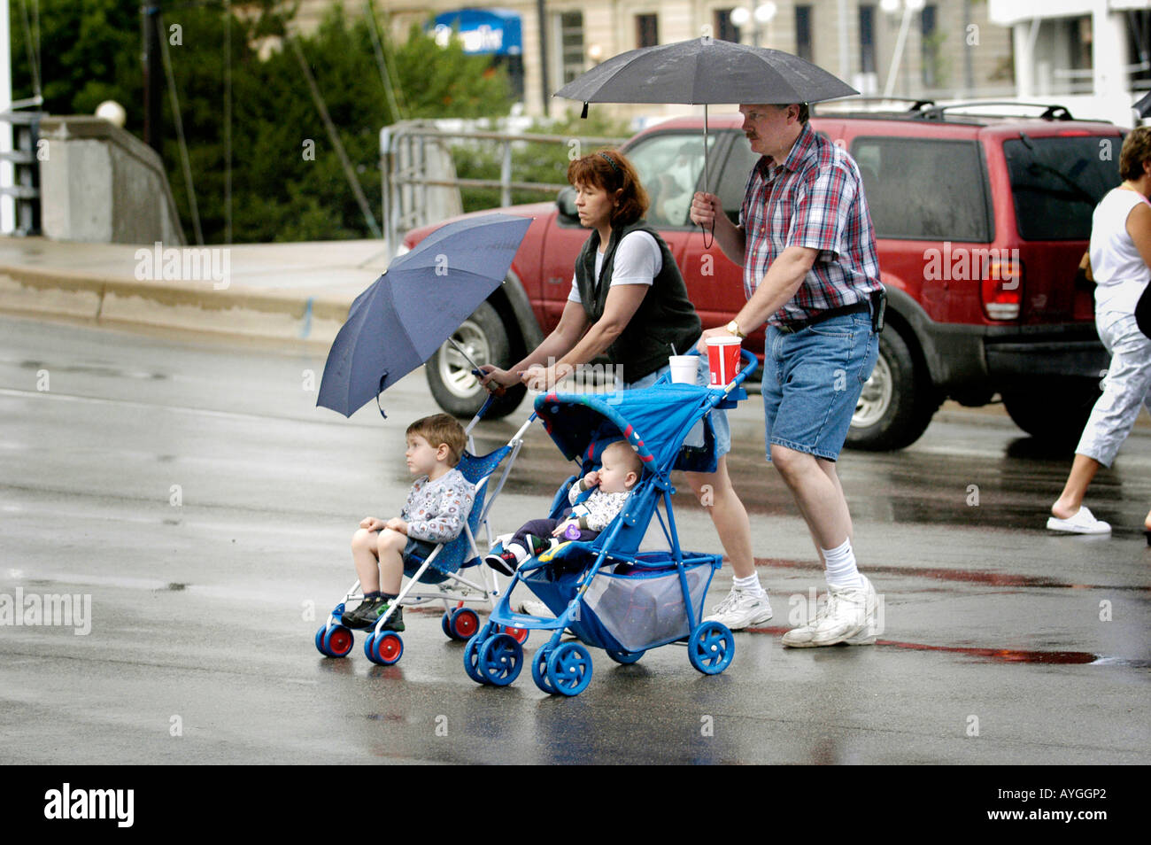 Pedestrian with umbrella protection is caught in rain storm on a public ...