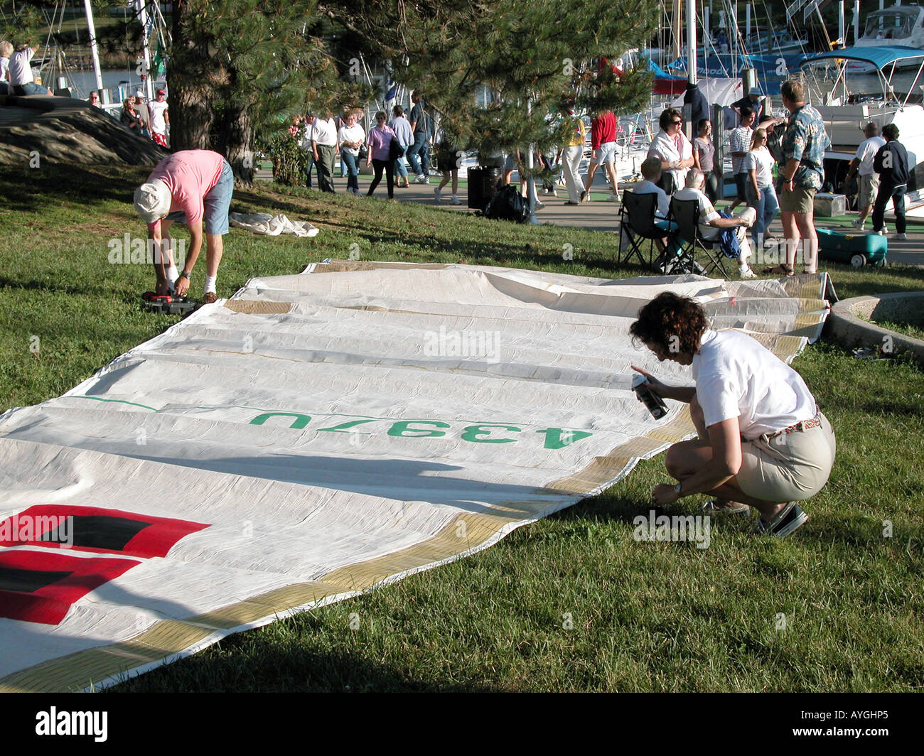 Couple effect repair on a sail Stock Photo - Alamy
