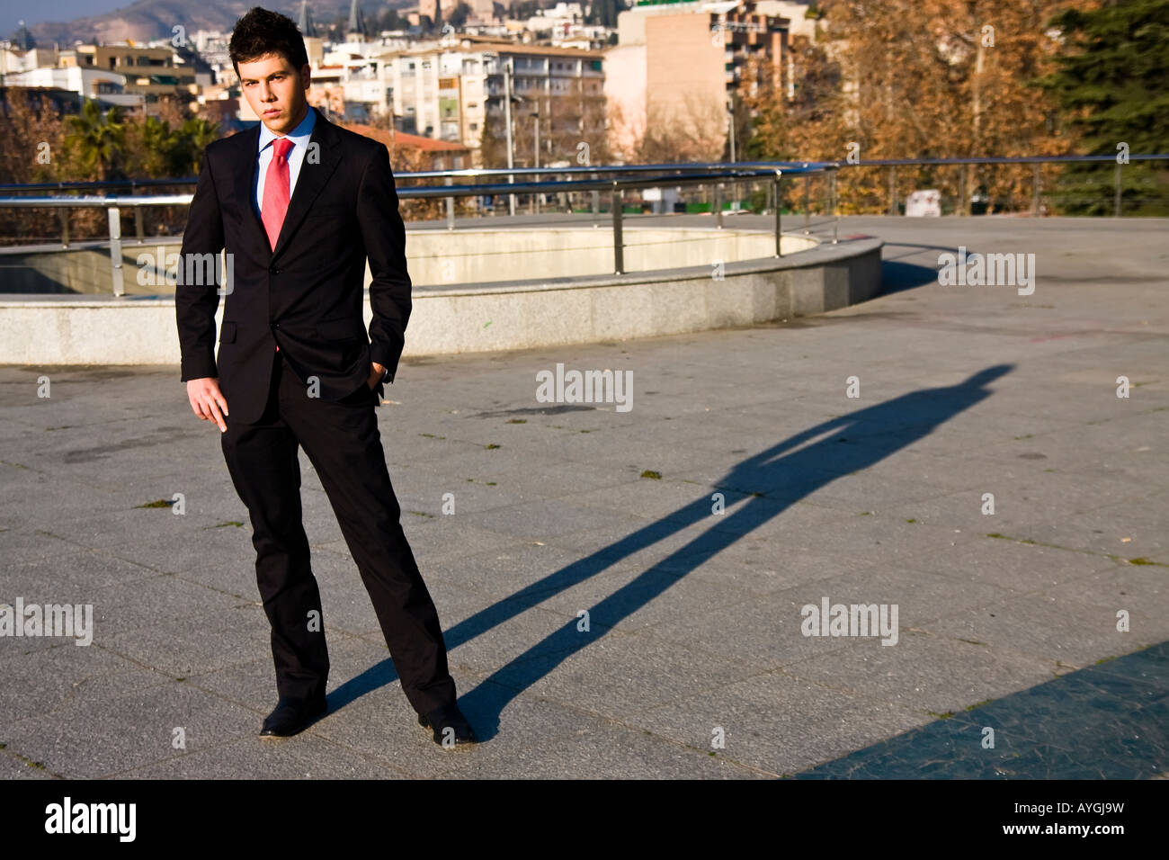 Standing businessman posing on city background Stock Photo - Alamy
