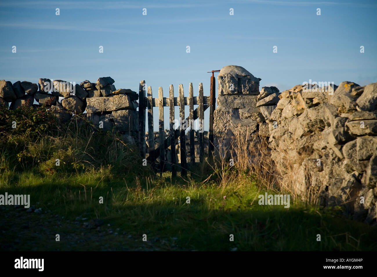 Photo of a wooden gate with a stone wall Stock Photo - Alamy