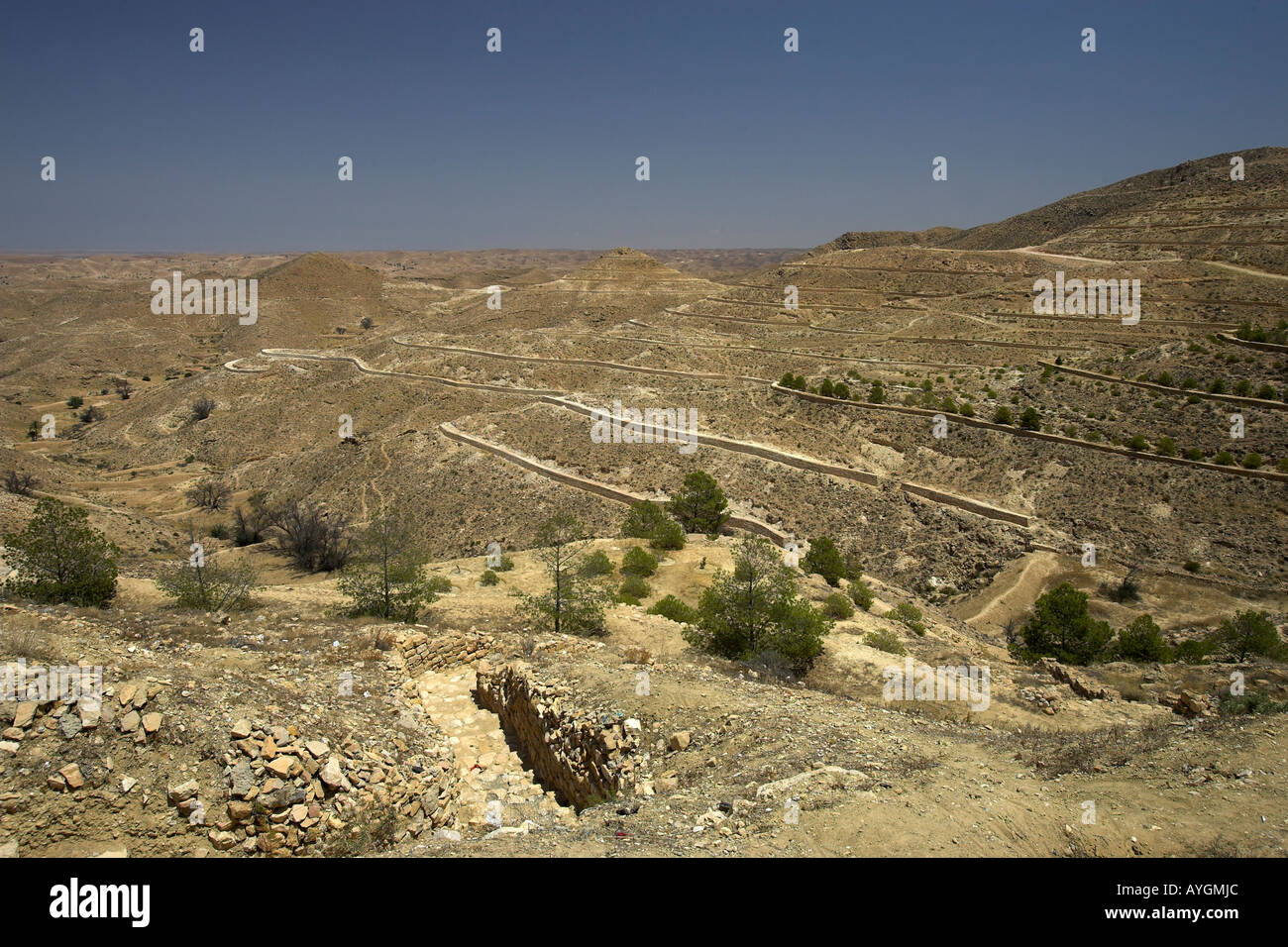 Desert landscape and escarpment retaining walls near Matmata Tunisia ...