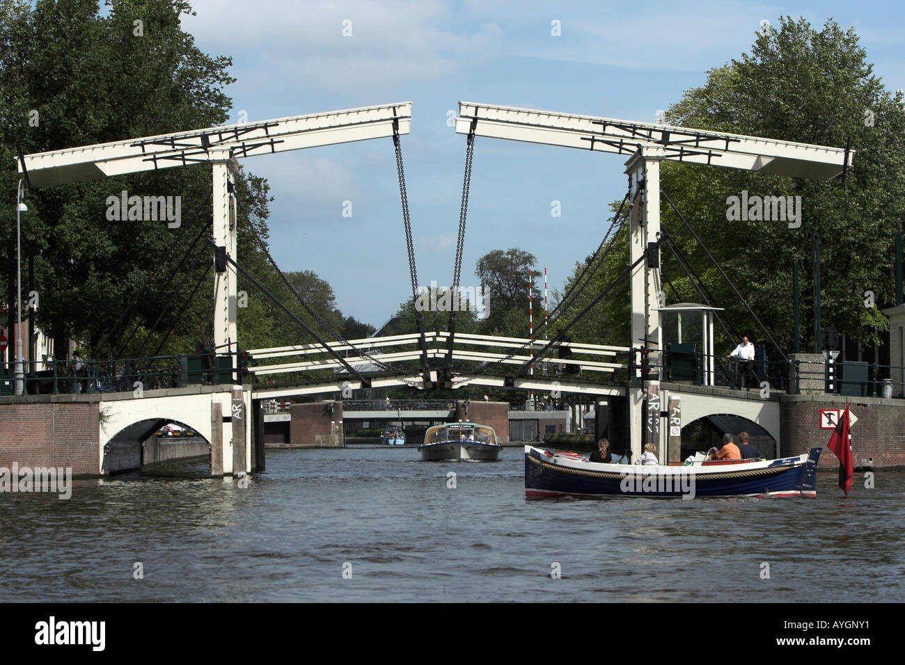 Swing bridge with tour boat and open traditional power boat Amsterdam ...