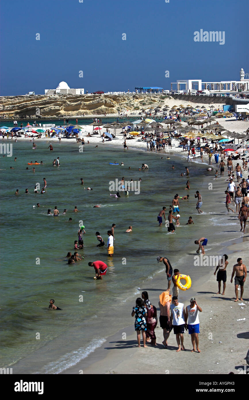 Holidaymakers cool off in water at Monastir Beach lined with sunshades ...