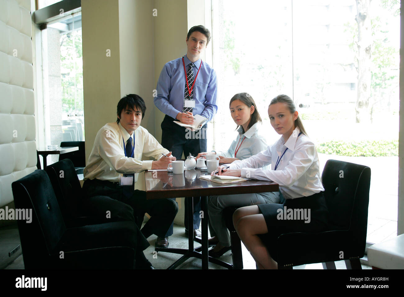 Portrait of four business people in cafe Stock Photo - Alamy