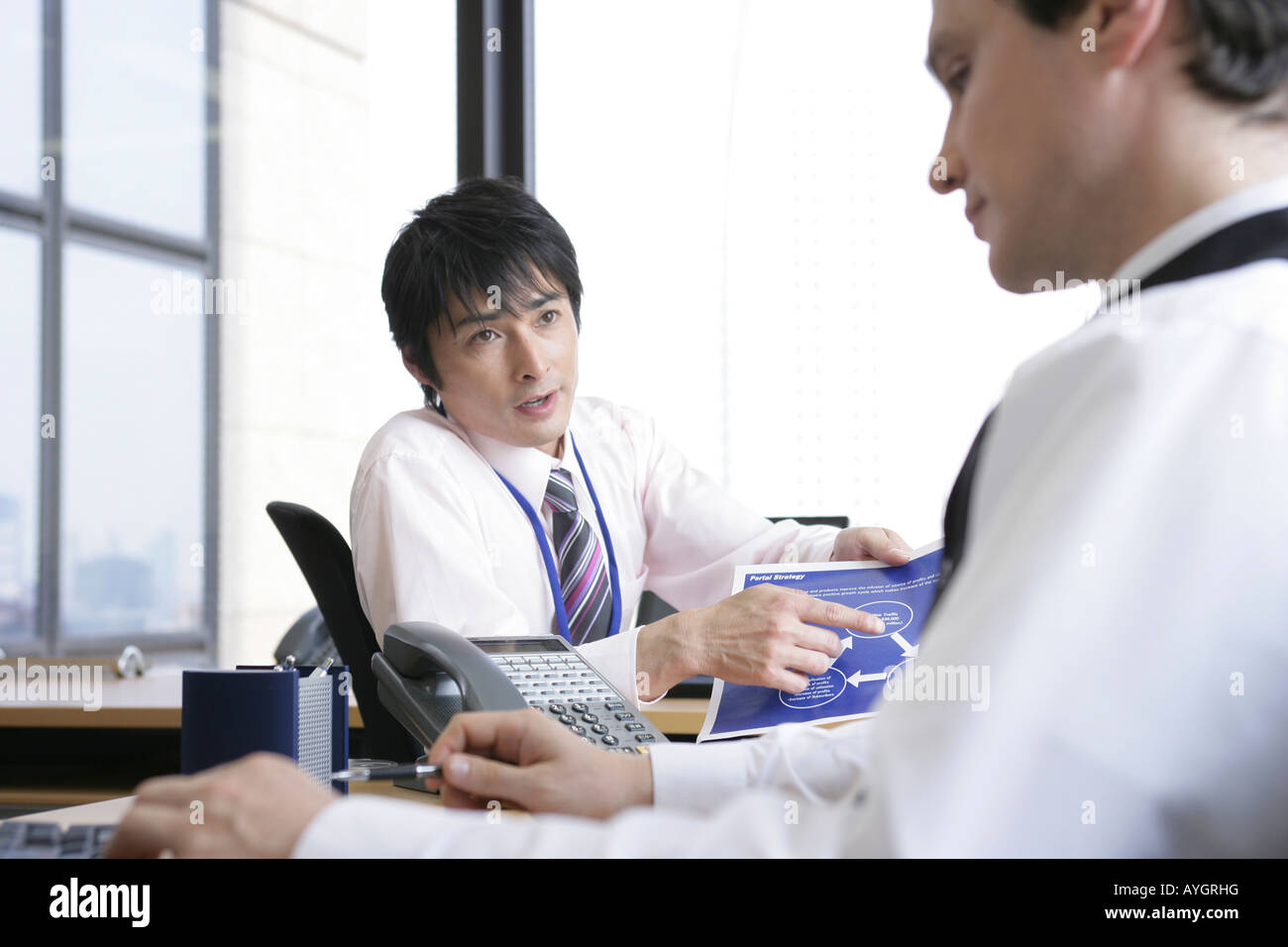 Two businessmen talking in office Stock Photo - Alamy