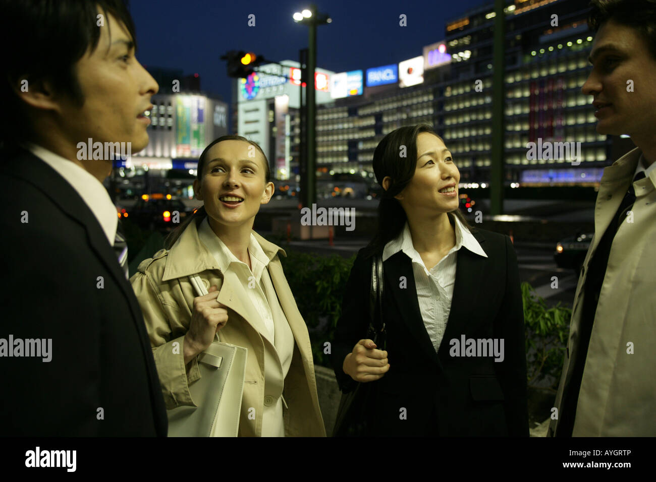 Four businesspeople talking outdoors at night Stock Photo - Alamy