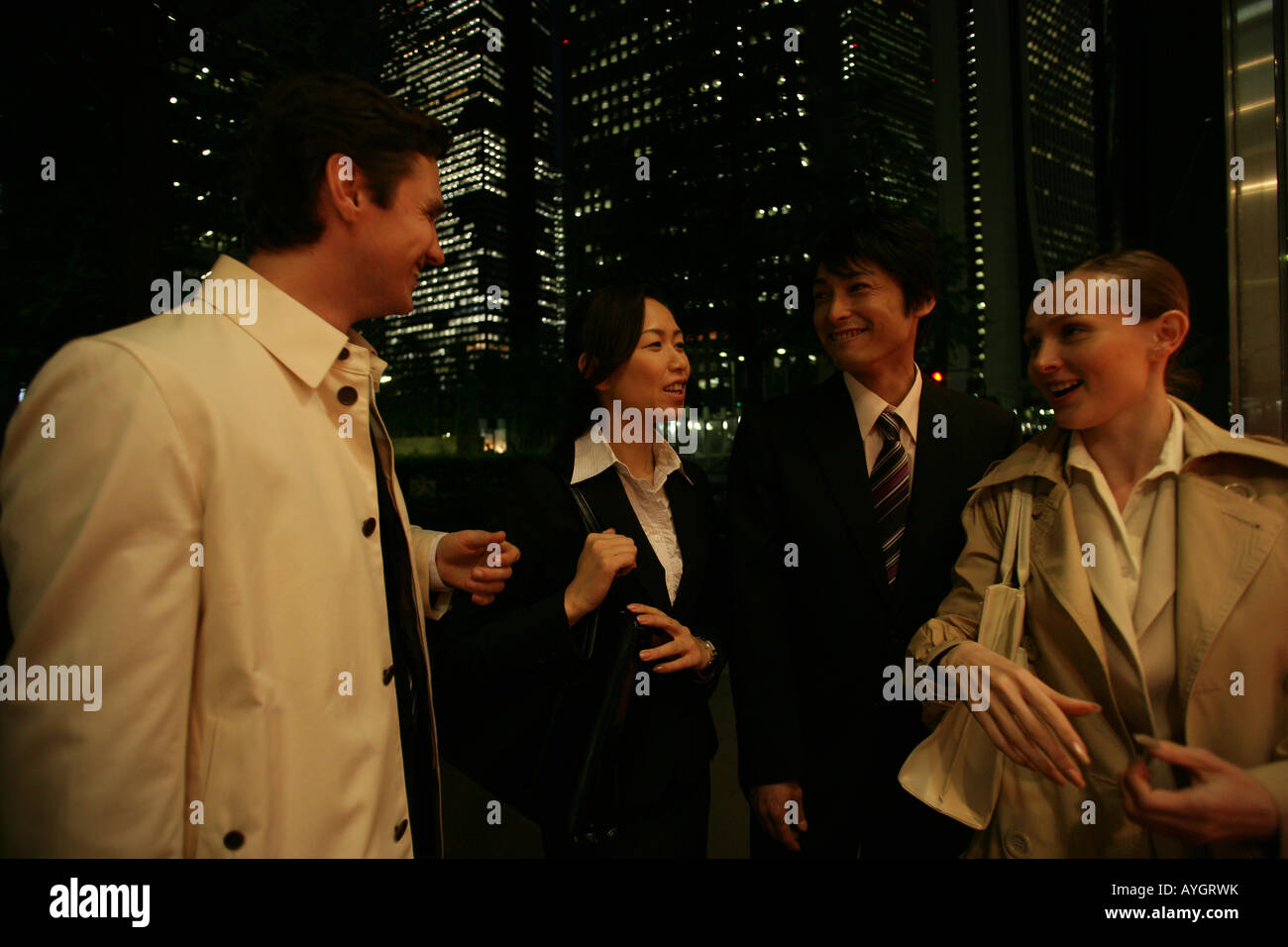 Four businesspeople talking outdoors at night Stock Photo - Alamy