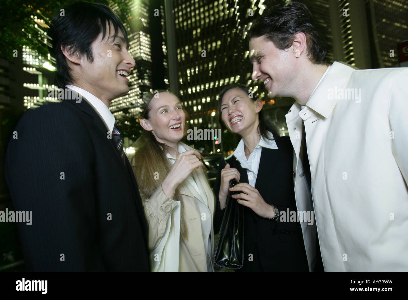 Four businesspeople talking outdoors at night Stock Photo - Alamy
