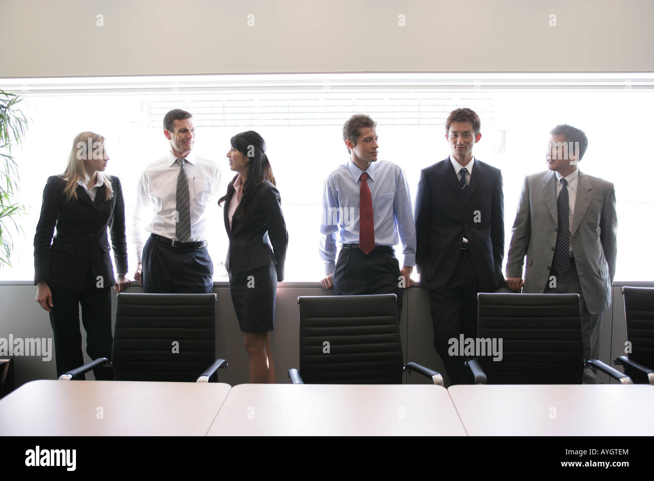 Group of business people talking and standing by window Stock Photo - Alamy