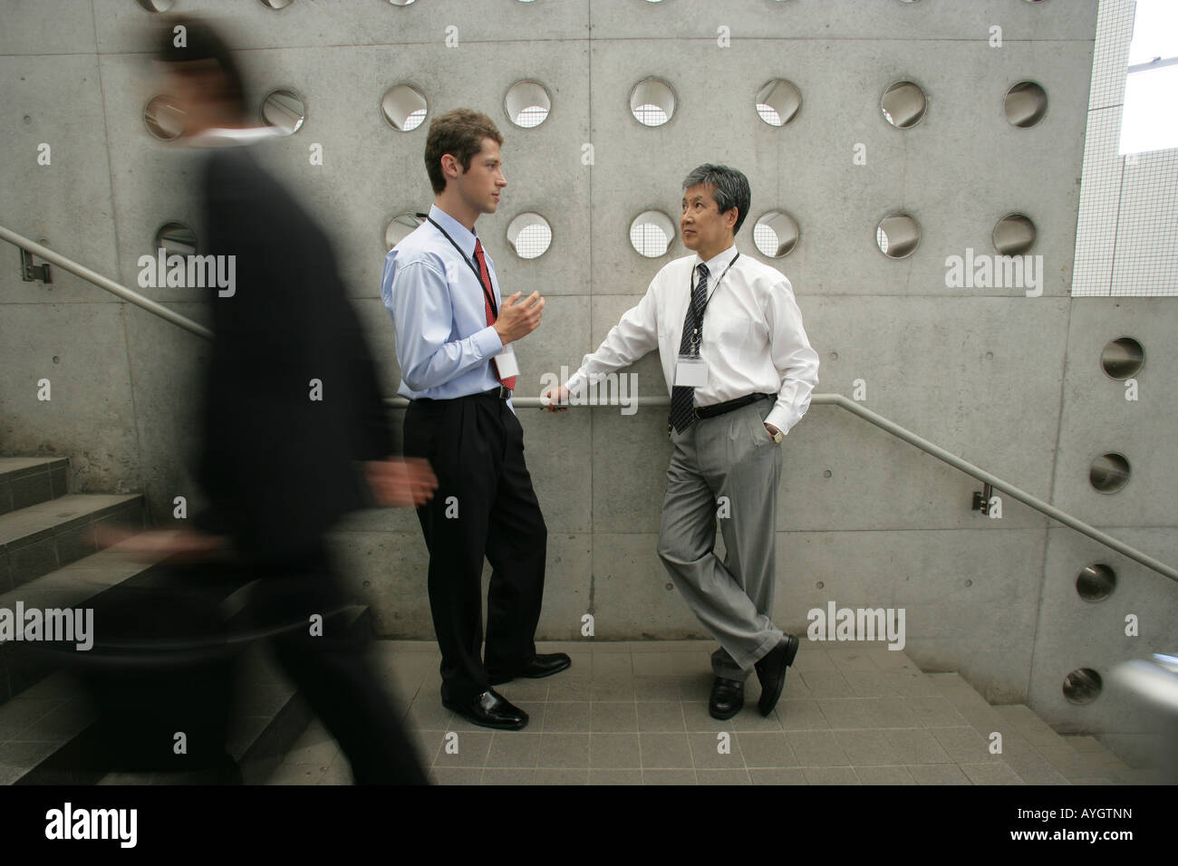 Two business men talking standing on staircase Stock Photo - Alamy