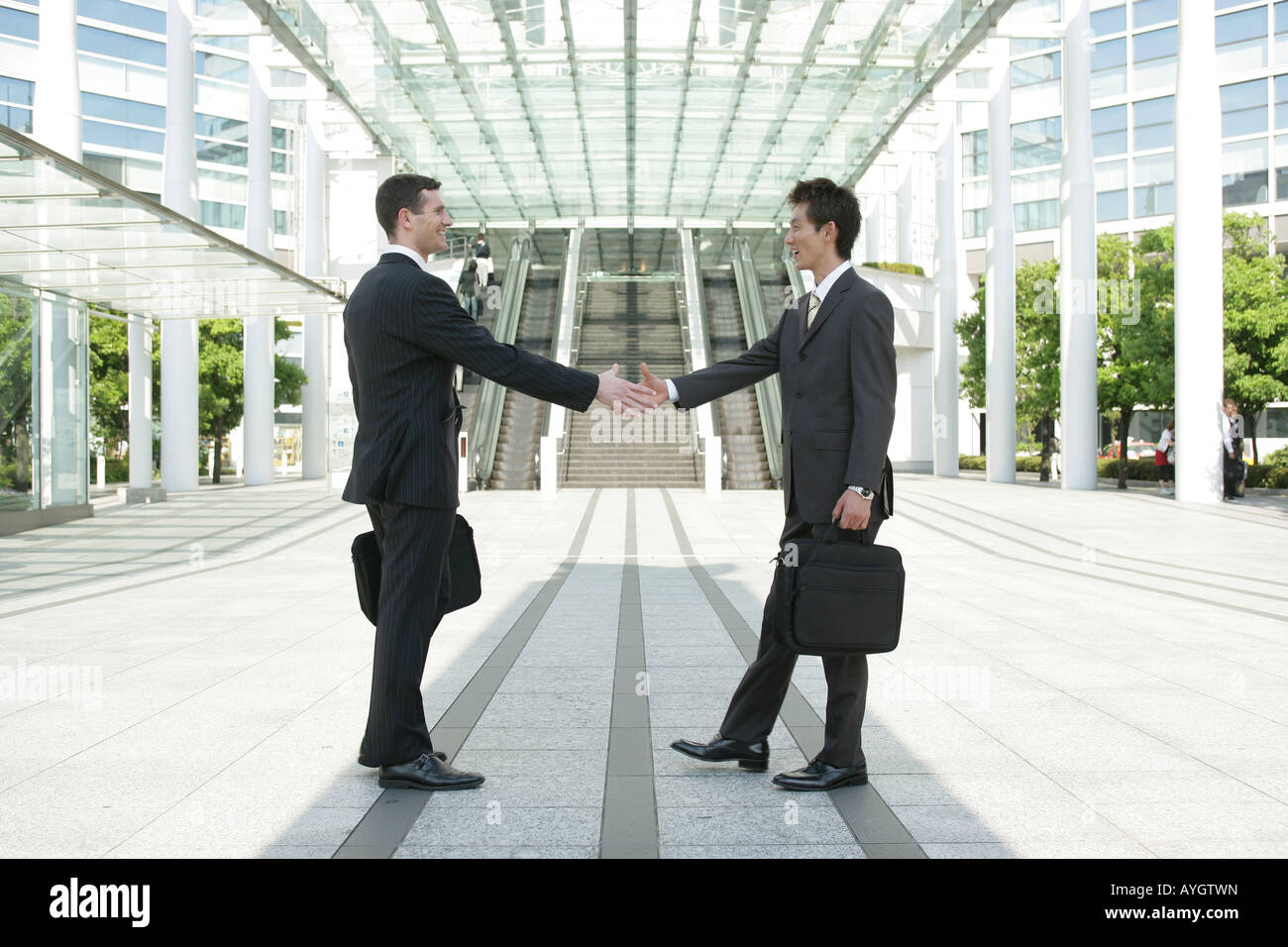 Two business people shaking hands outside office building Stock Photo ...