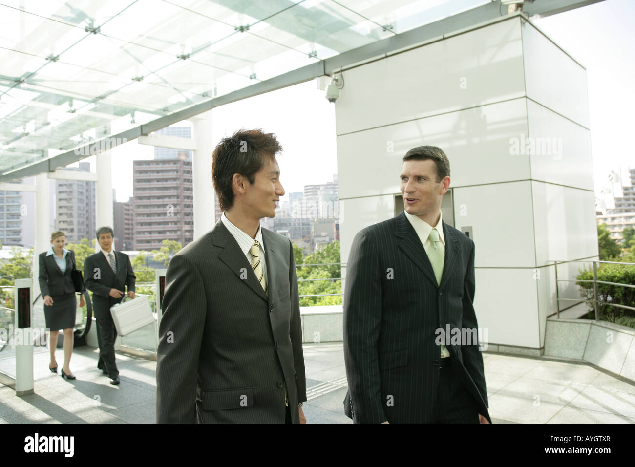 Two business people walking outside office building Stock Photo - Alamy