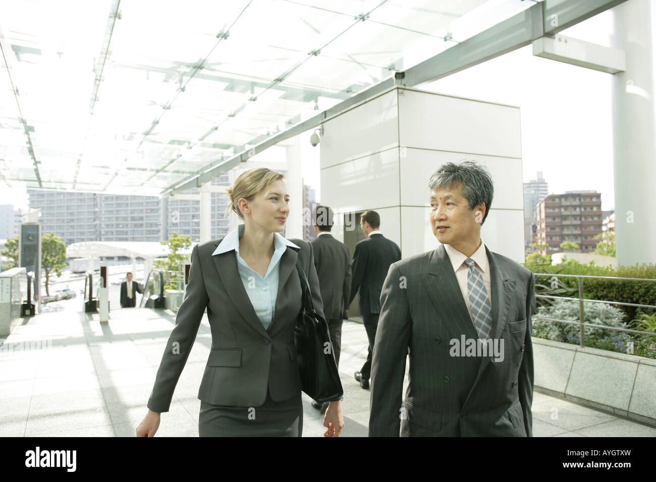 Business couple walking outside office building Stock Photo - Alamy