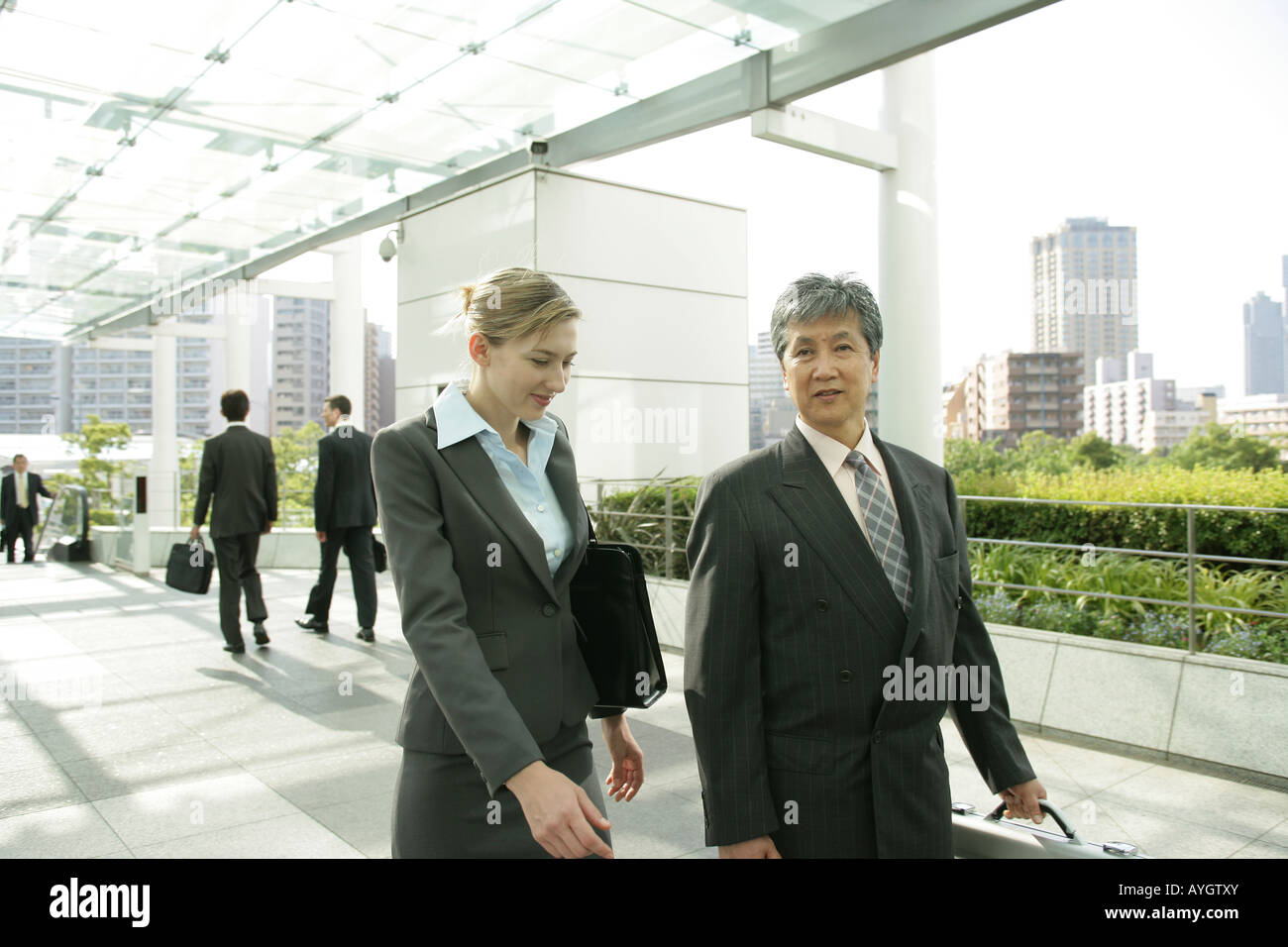 Business couple walking outside office building Stock Photo - Alamy