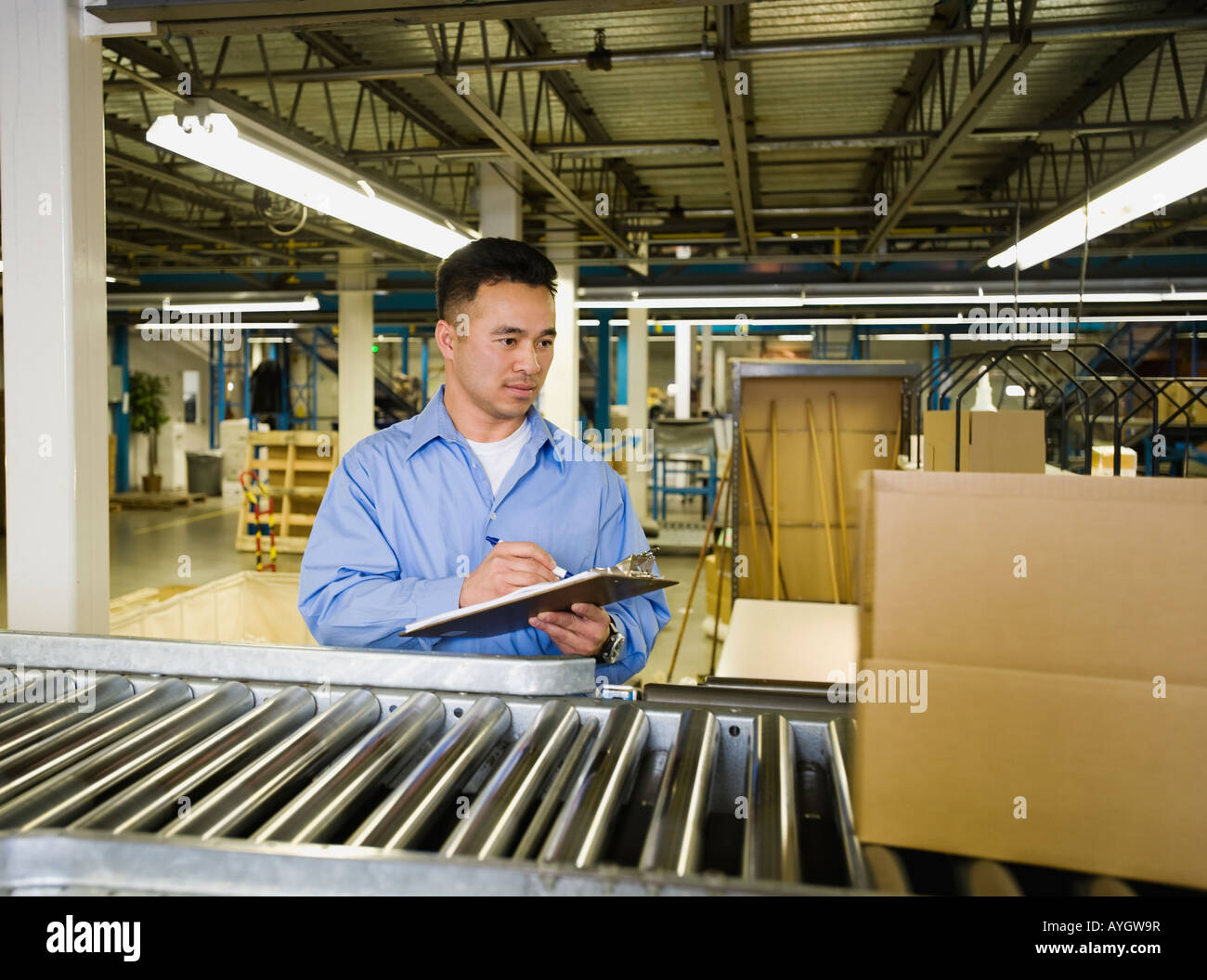 Asian male factory worker checking product Stock Photo - Alamy