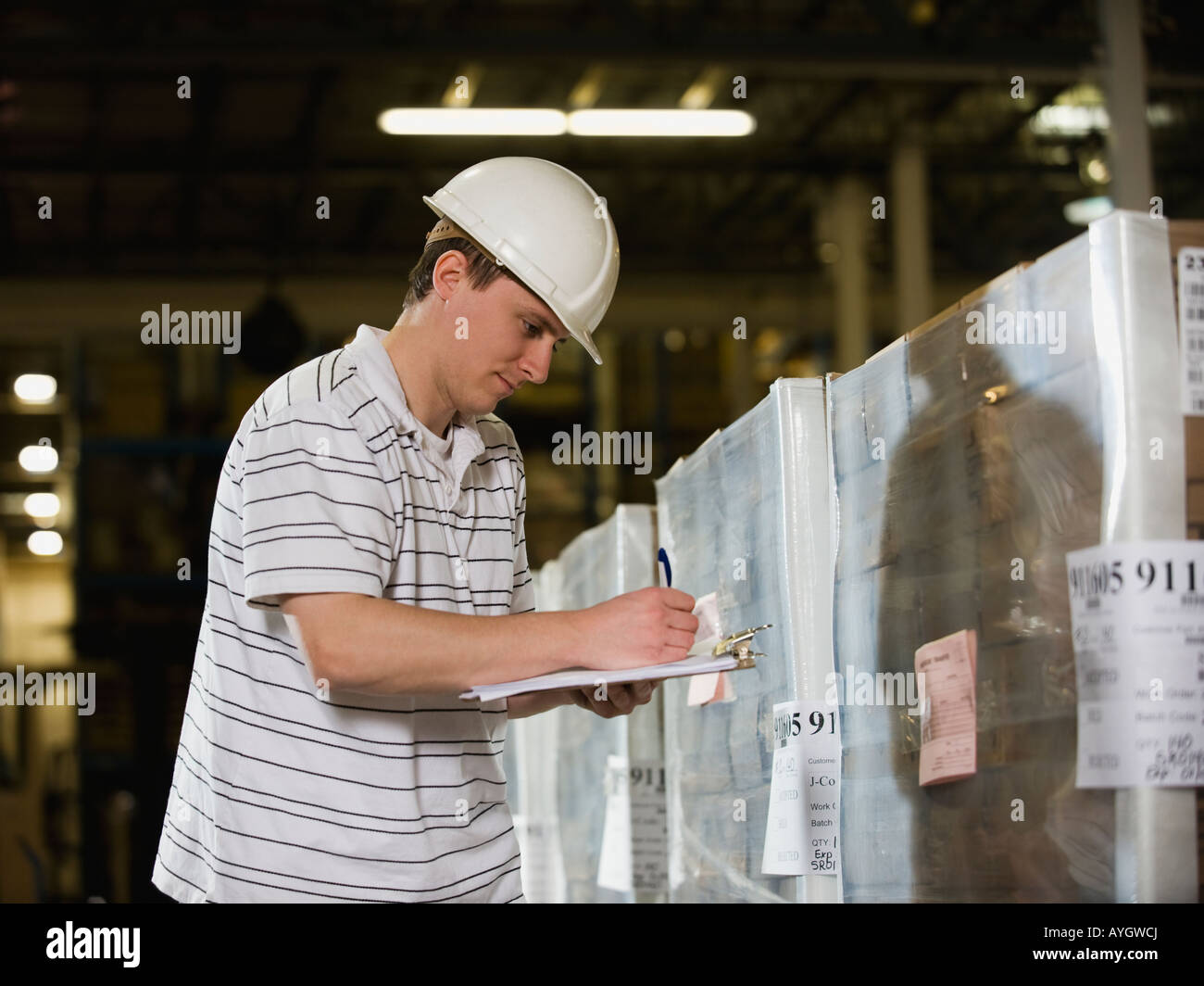 Warehouse worker writing on clipboard Stock Photo - Alamy