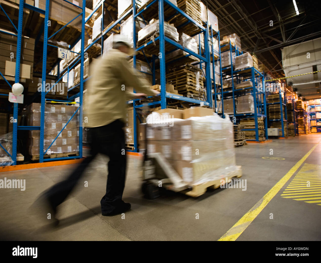 Warehouse worker pushing palette Stock Photo - Alamy
