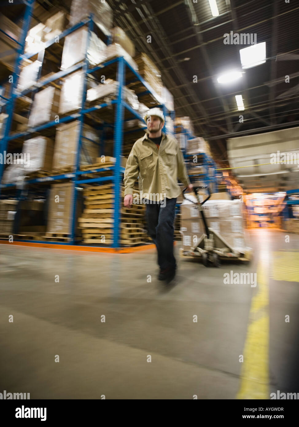 Warehouse worker pulling palette Stock Photo - Alamy