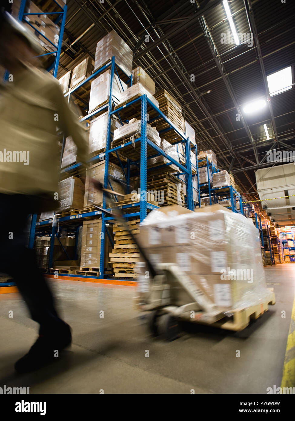 Warehouse worker pulling palette Stock Photo - Alamy