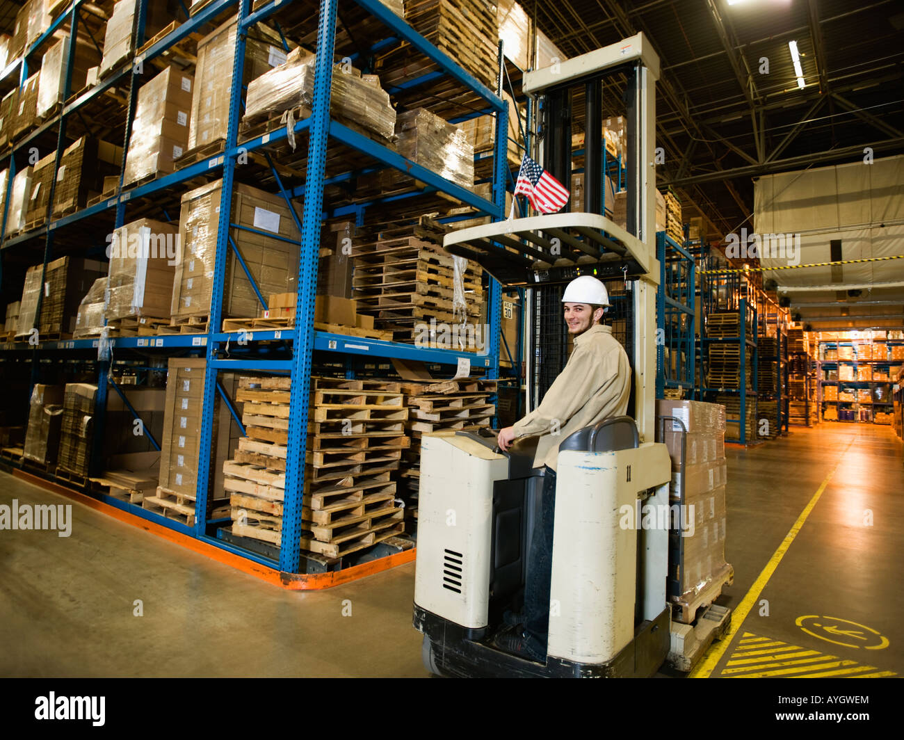 Warehouse worker driving forklift Stock Photo - Alamy