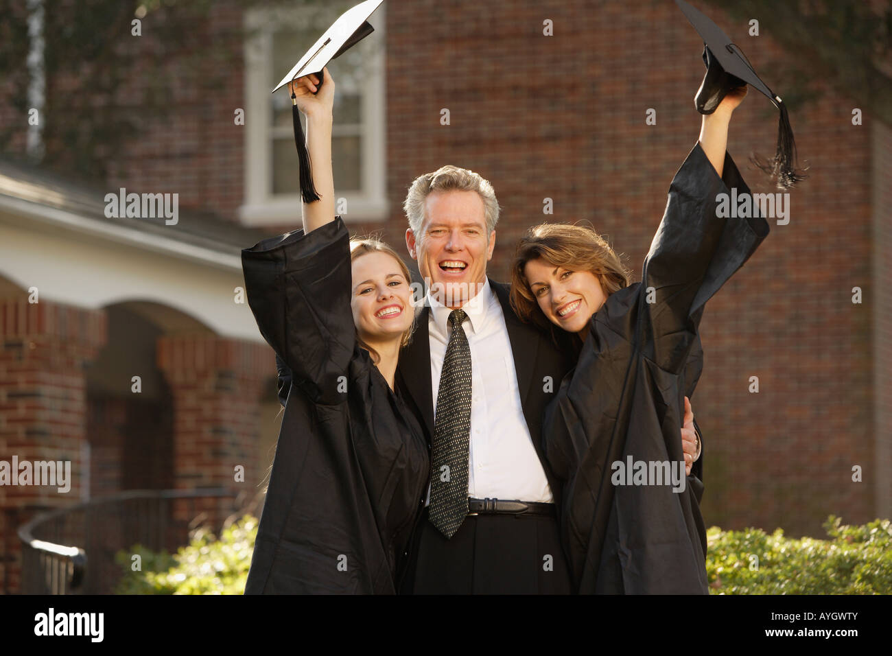 Women graduates with father cheering Stock Photo - Alamy