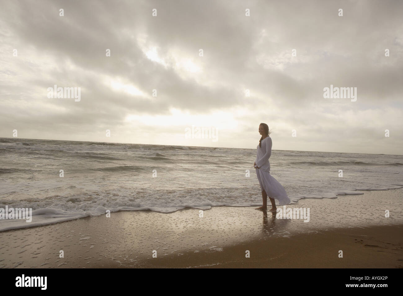 Woman standing in ocean surf Stock Photo - Alamy