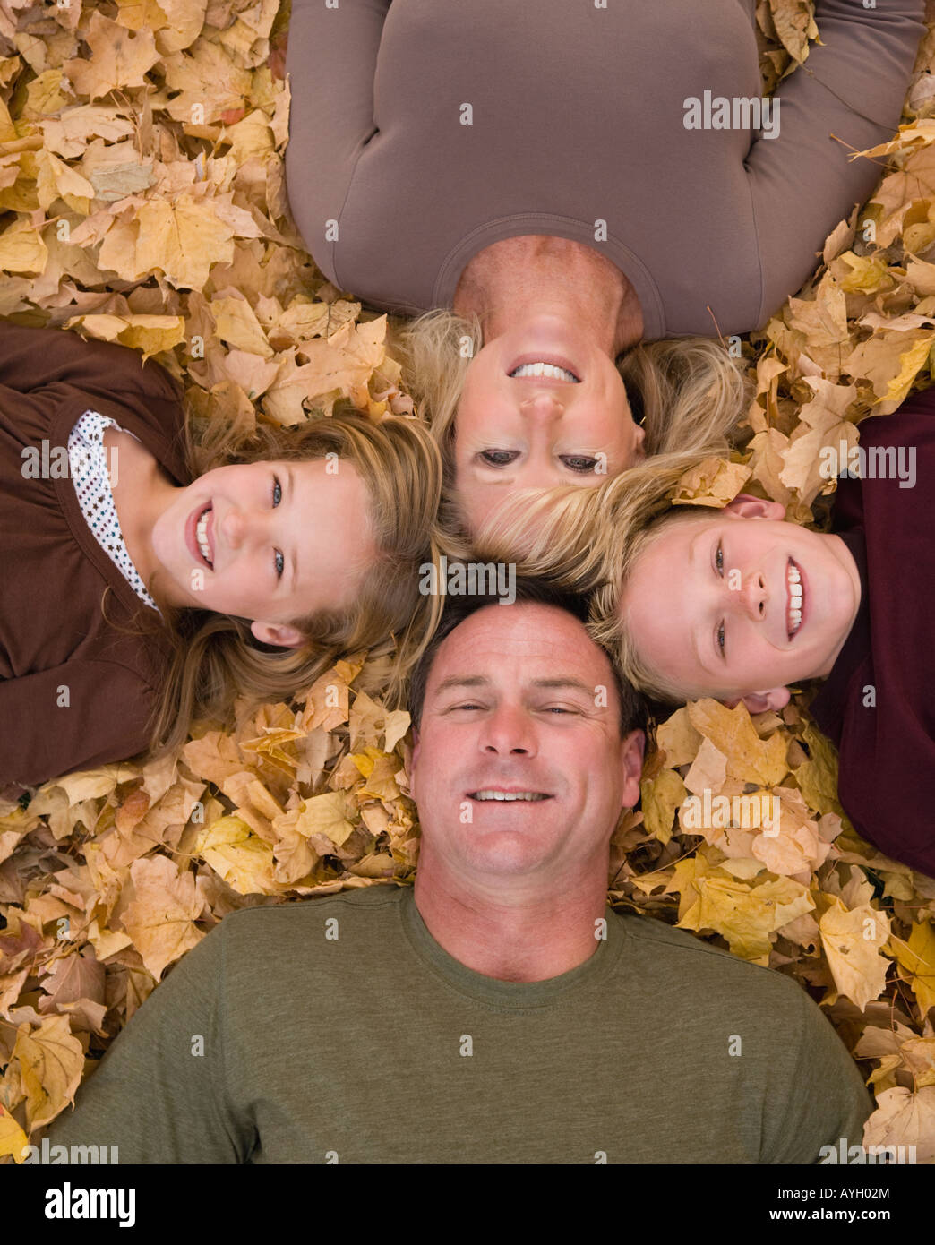 Family laying in autumn leaves Stock Photo - Alamy