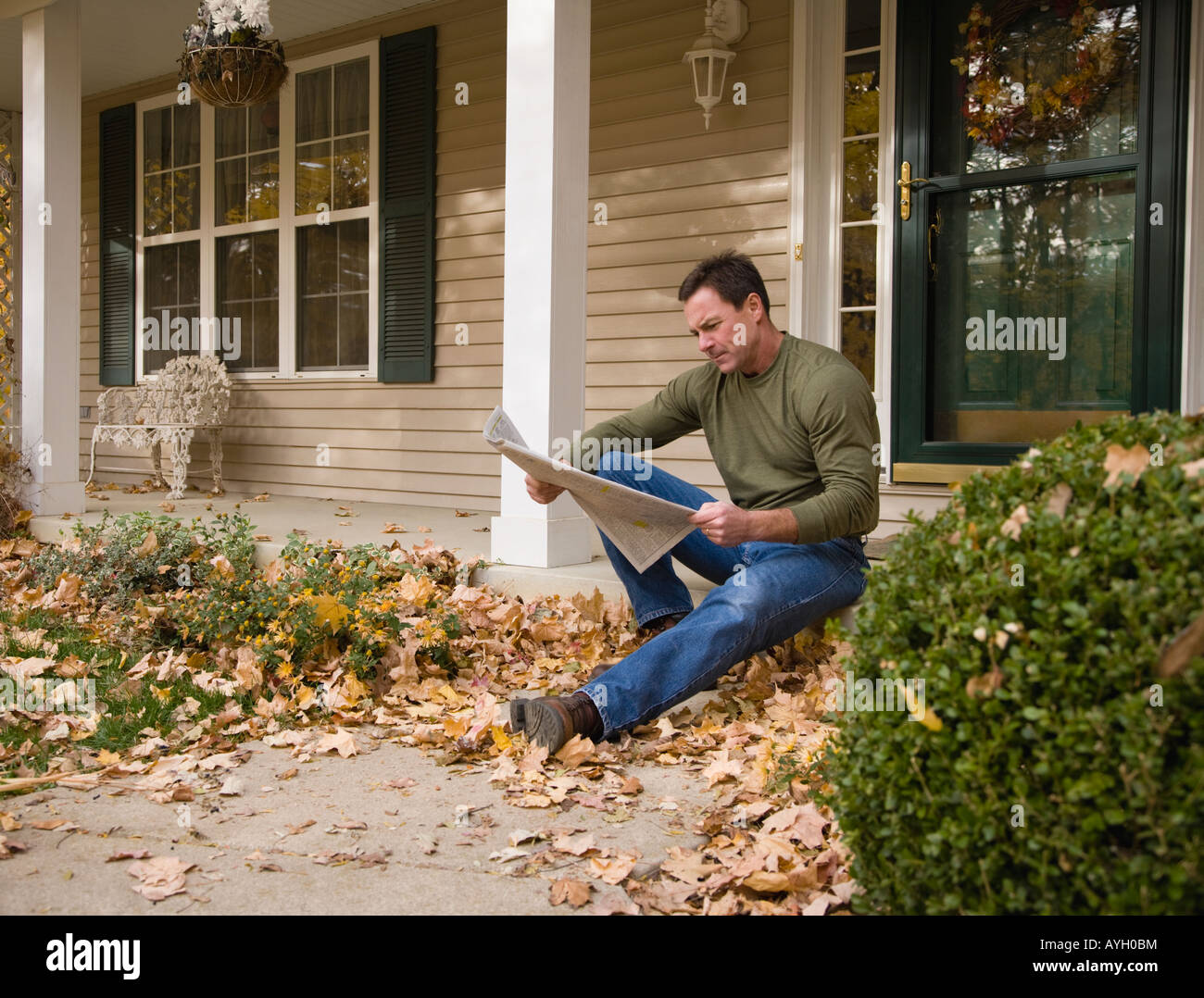 Man reading newspaper on porch Stock Photo - Alamy