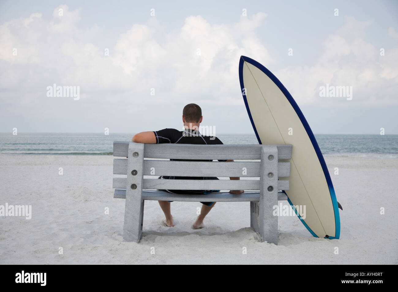 Surfer sitting on bench next to surfboard Stock Photo - Alamy