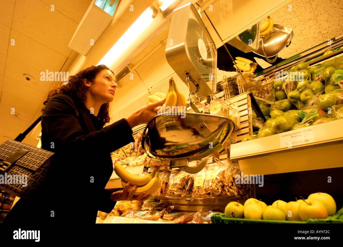 A young woman shopper weighing fruit at Waitrose Britains leading ...