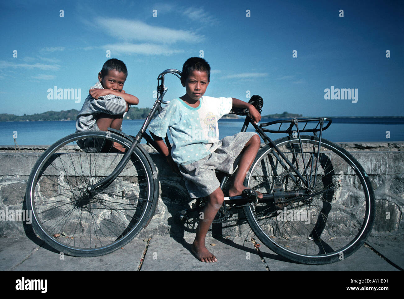 Two boys and a relatively oversized bicycle beside the waterfront Pare ...