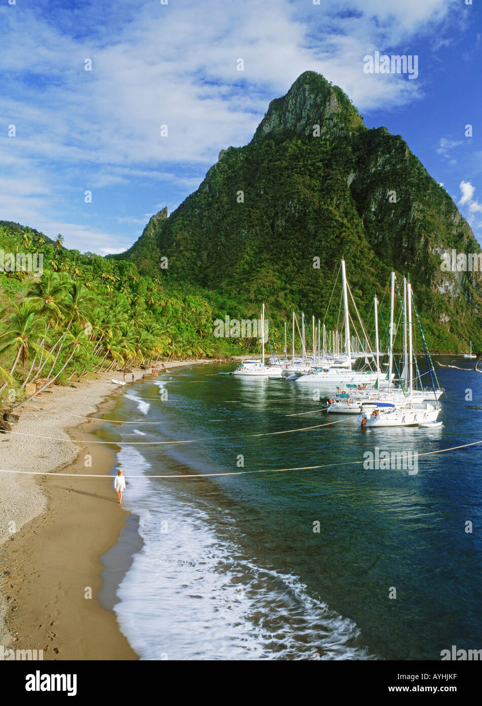 Woman walking on sandy shore at Margretoute Bay below Petit Piton ...