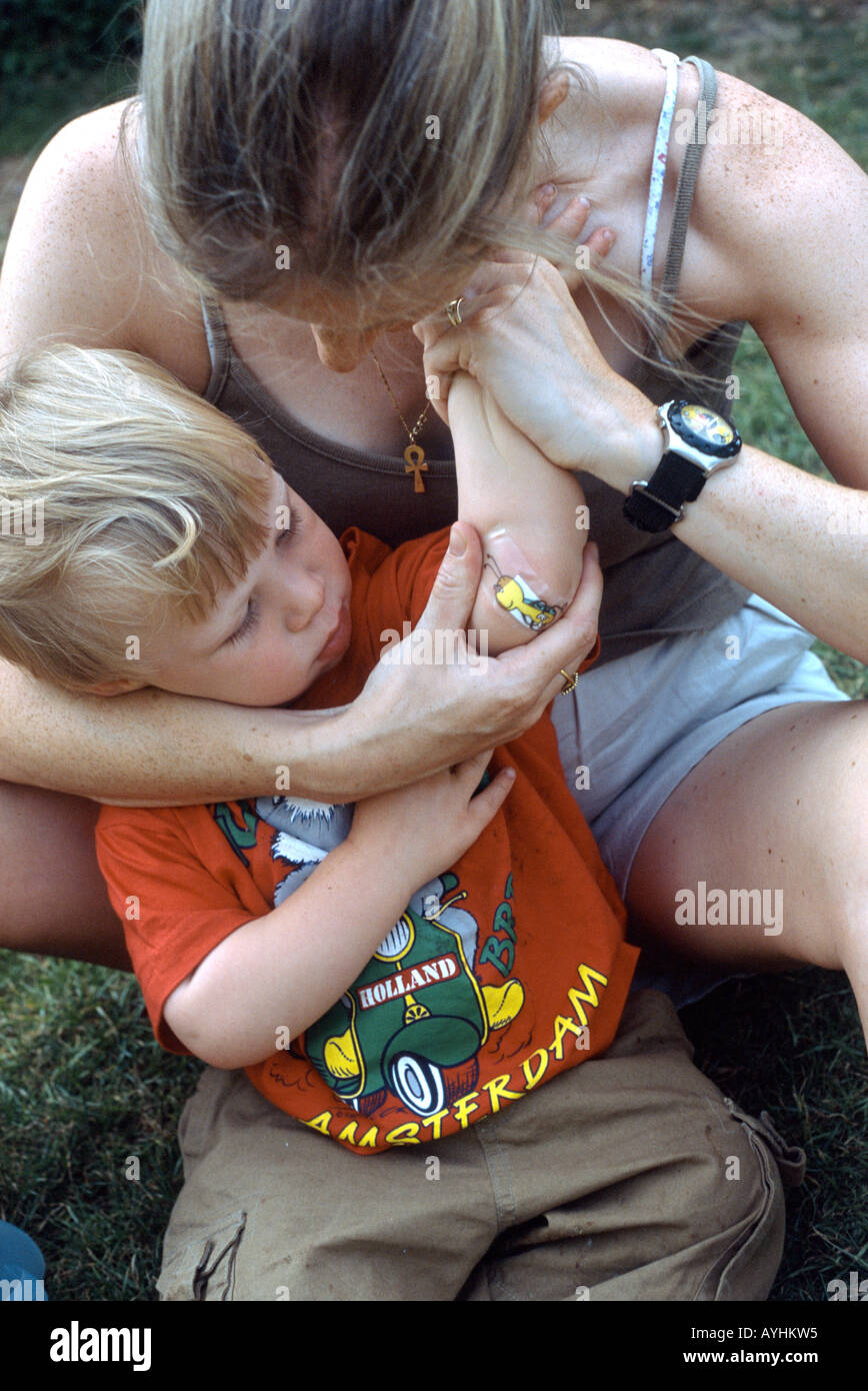 mother applying a plaster to son's scraped elbow Stock Photo - Alamy