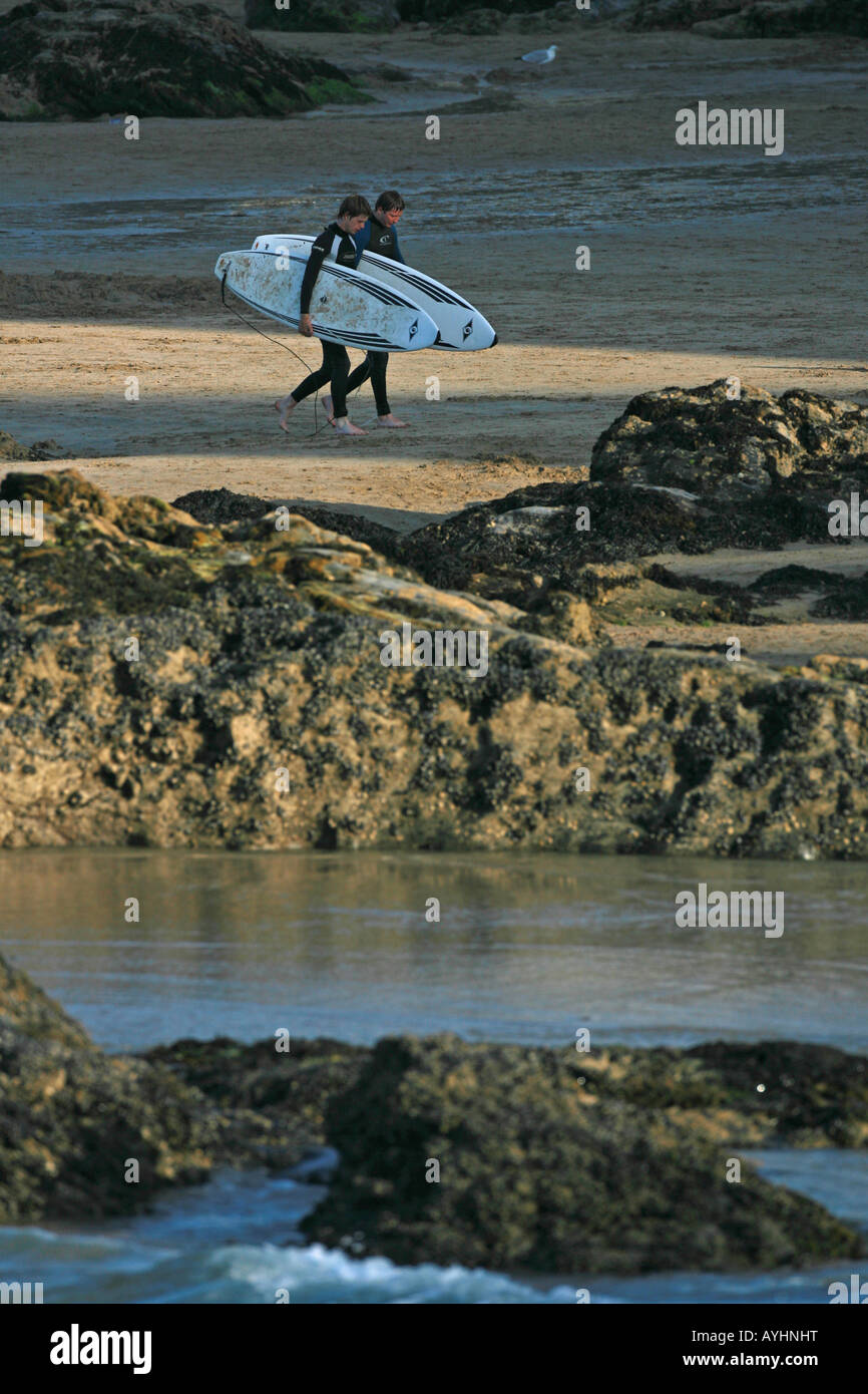 A pair of surfers walking across a beach with their surf boards Stock ...