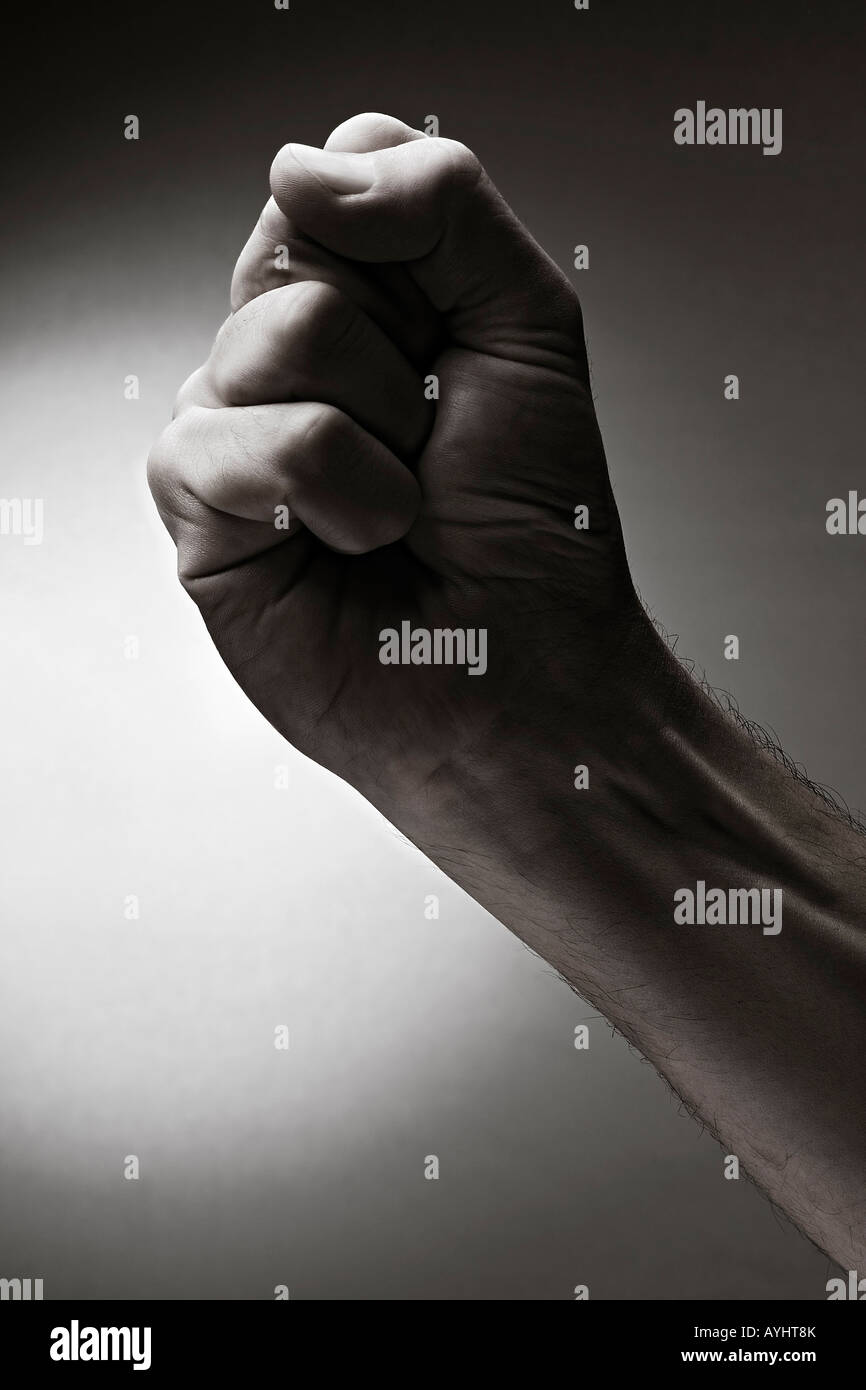 a clenched fist in dramatic light Stock Photo - Alamy