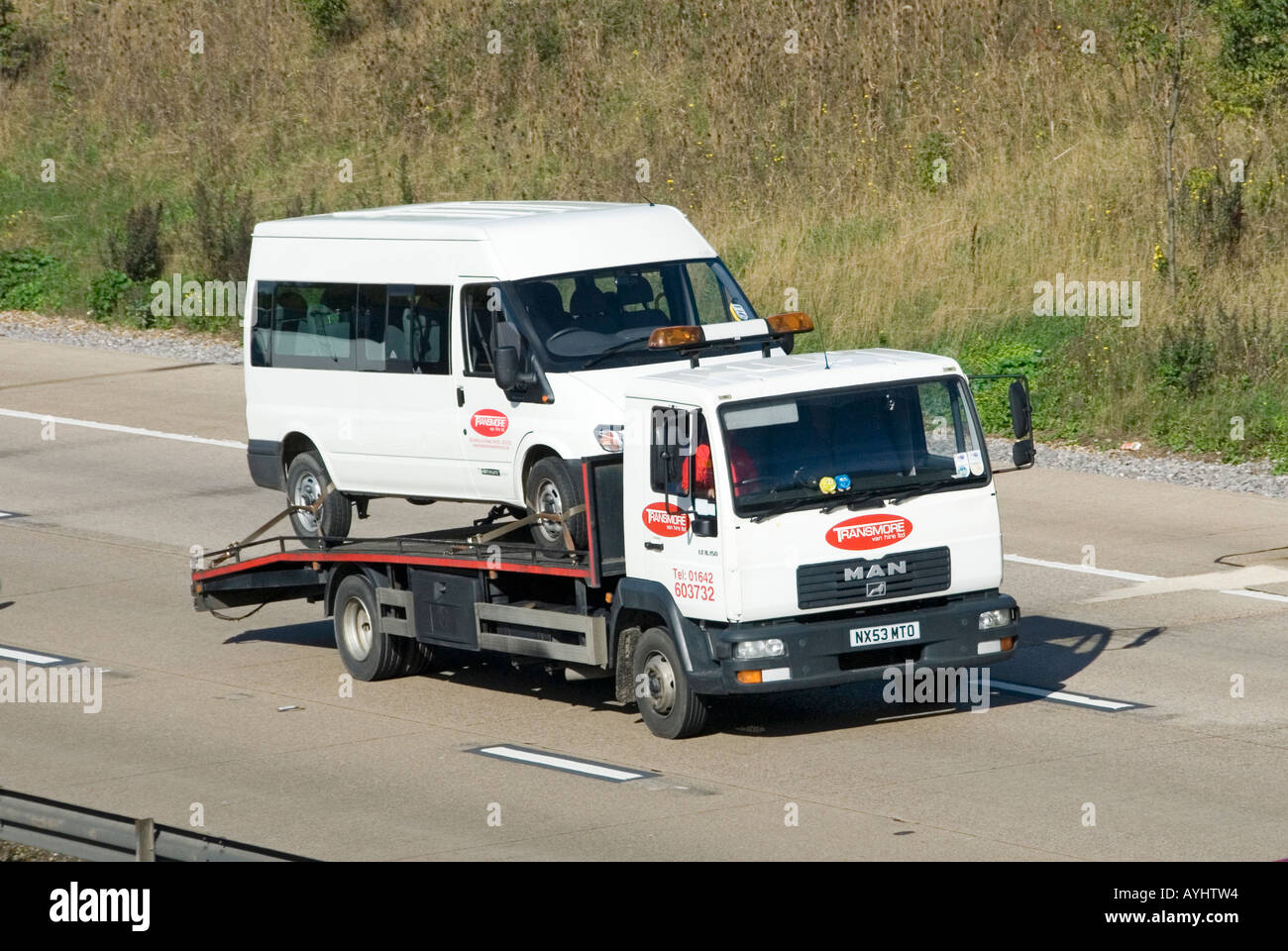 Mini bus on vehicle transporter travelling on motorway Stock Photo - Alamy