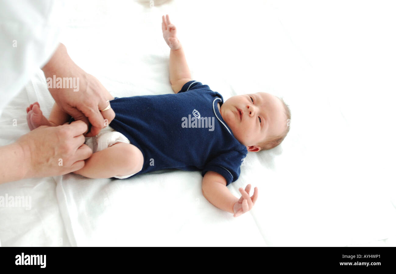 Newborn baby boy of one day old getting dressed Stock Photo - Alamy