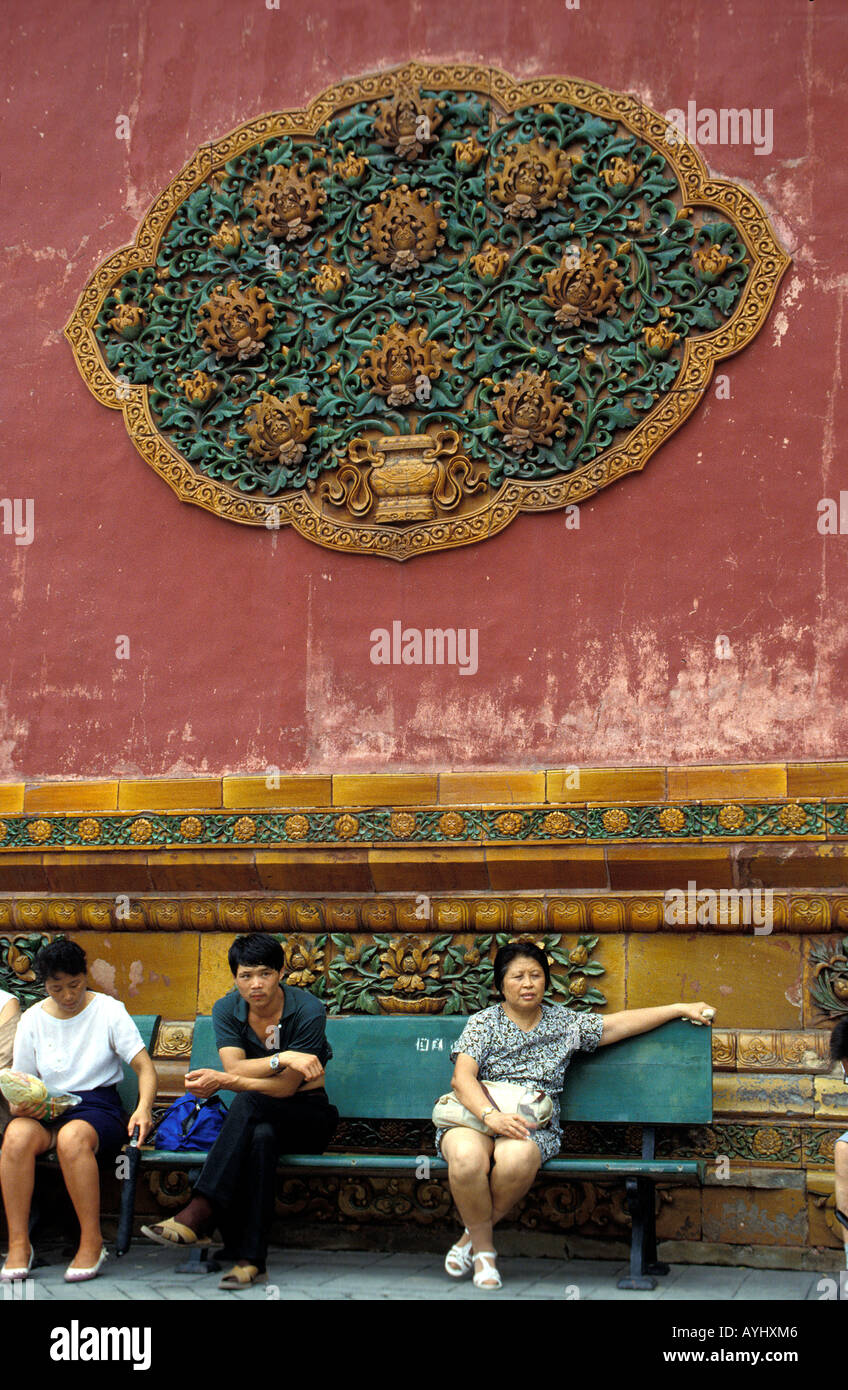 Beijing citizens resting on a bench at the wall of the forbidden city ...