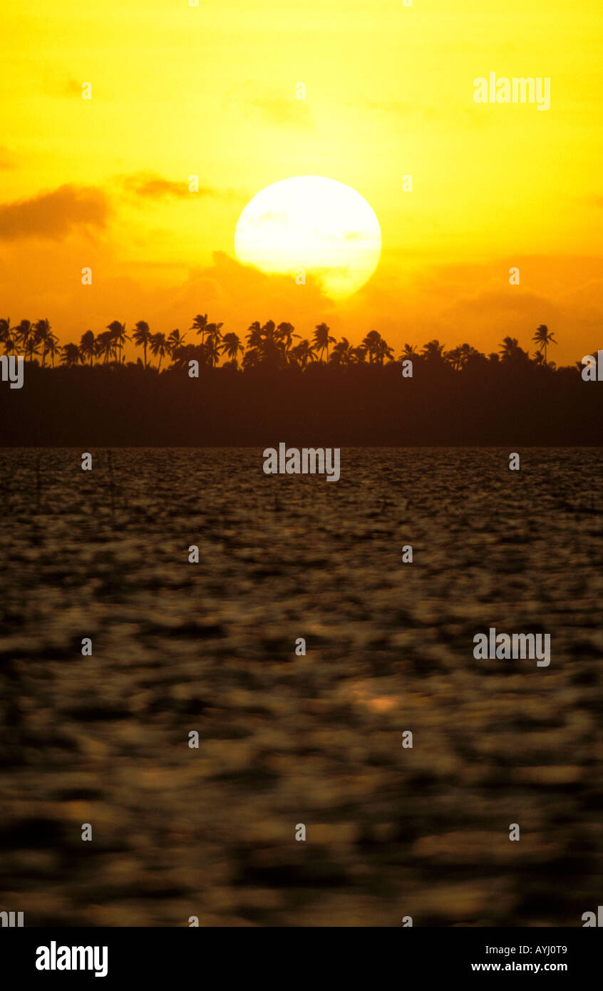 Sun setting over ocean Stock Photo - Alamy