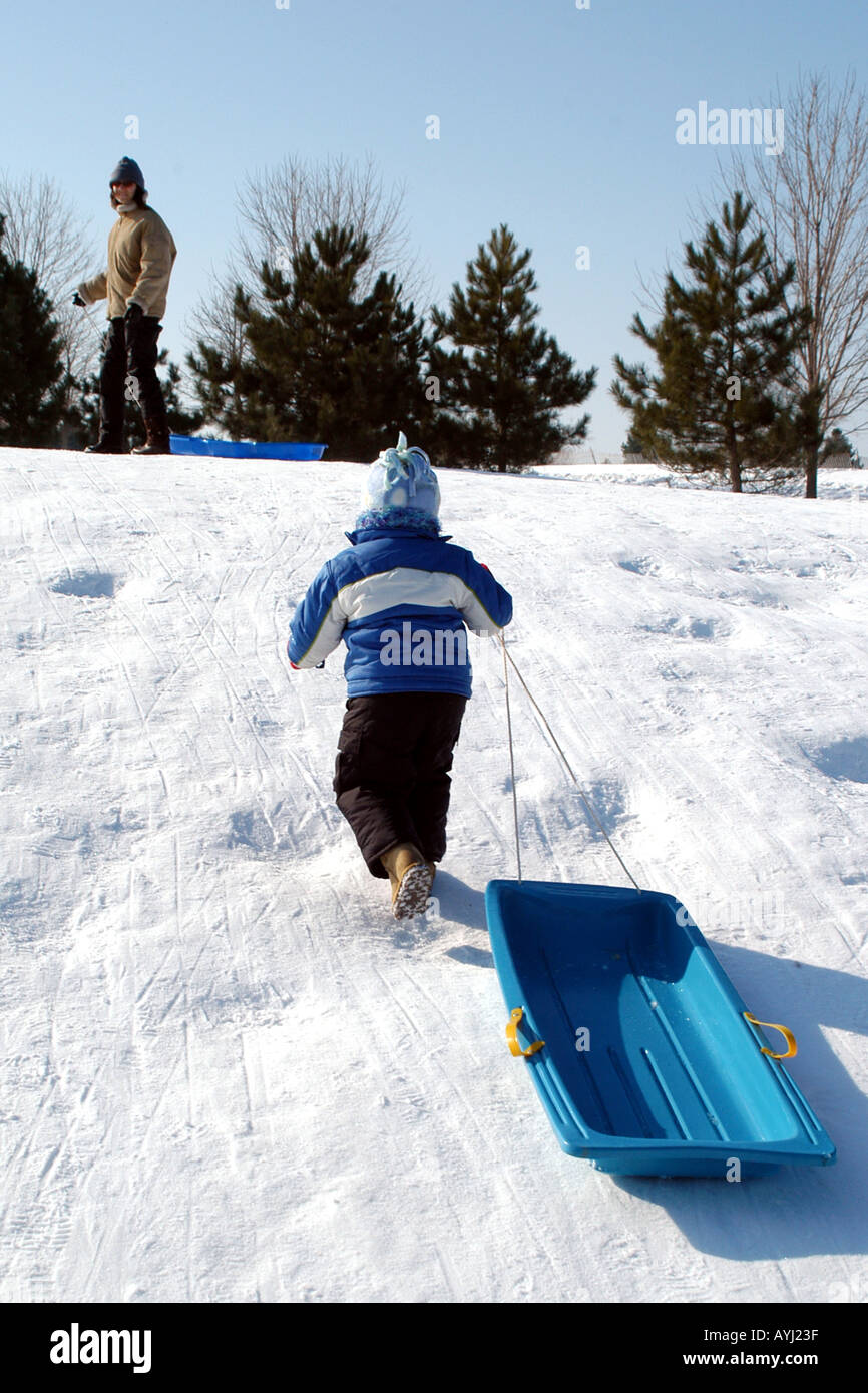 Child pulling a sled up hill Stock Photo - Alamy