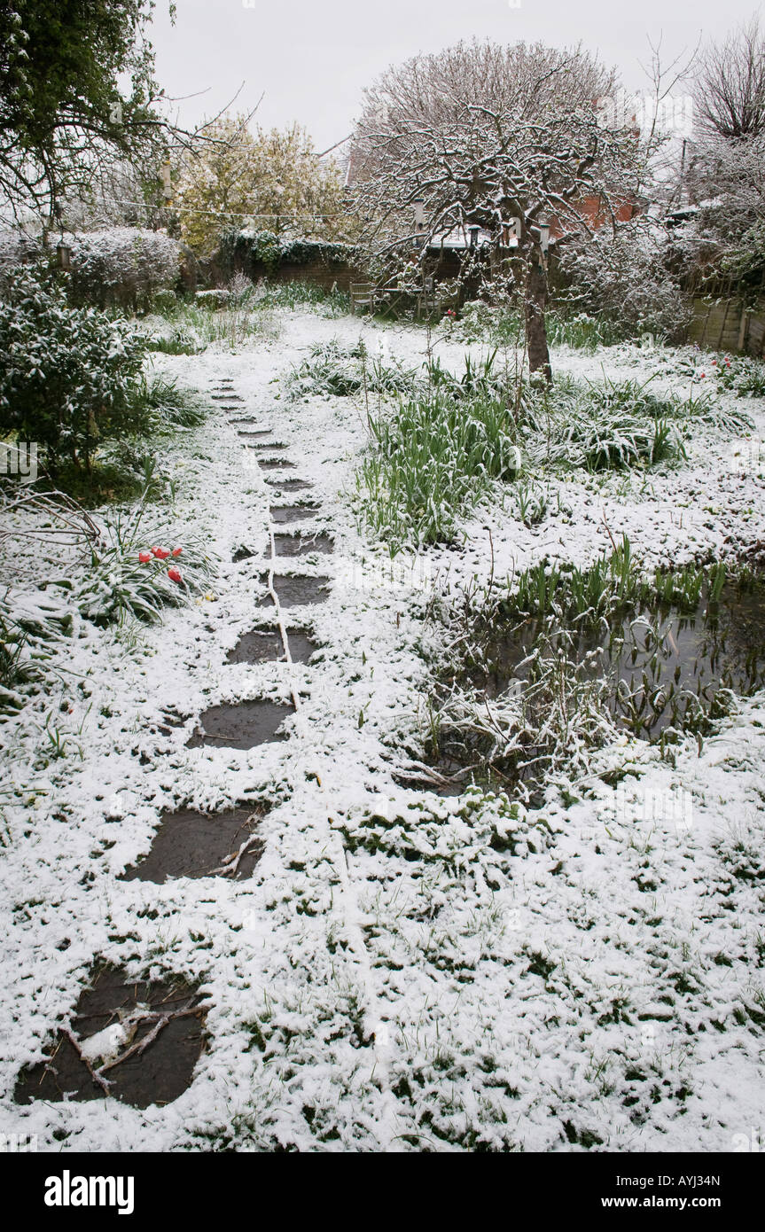 Looking along a paving stone pathway to a snow covered garden Stock ...