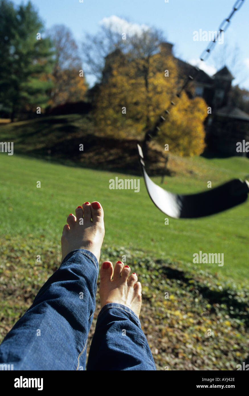 Jean clad legs with feet and toes sticking out flying swing in air ...