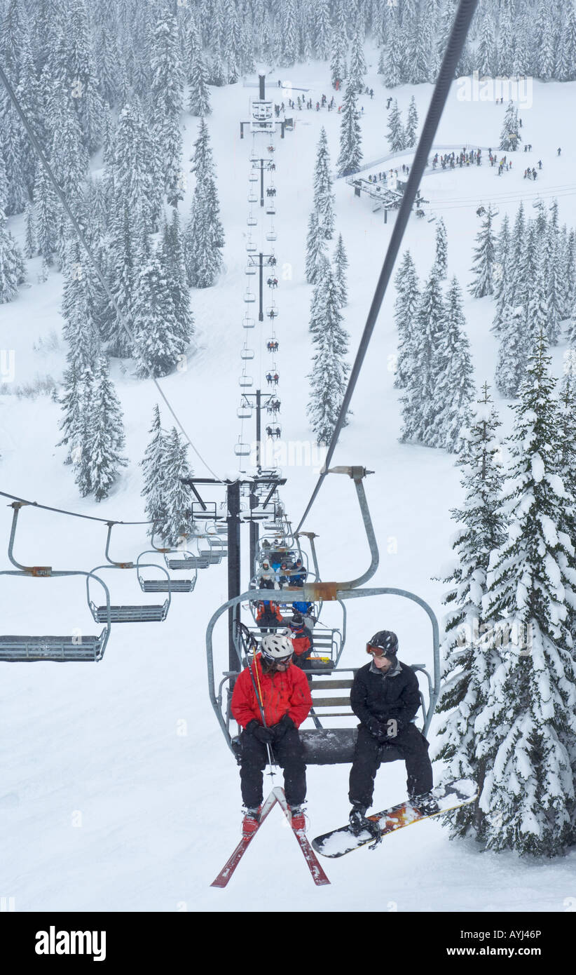 Ski lift and skiiers on the back side of Stevens Pass ski area ...